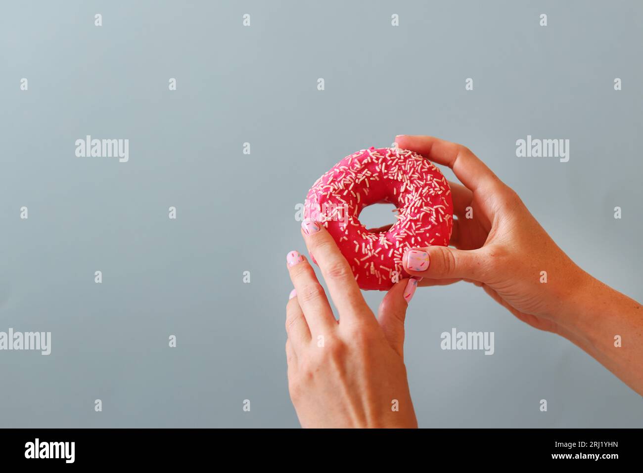 Female hand holding sweet donut with beautiful pink nails Stock Photo ...