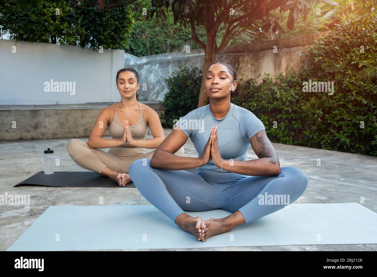 Positive calm millennial black and arab women do breathing exercises in ...