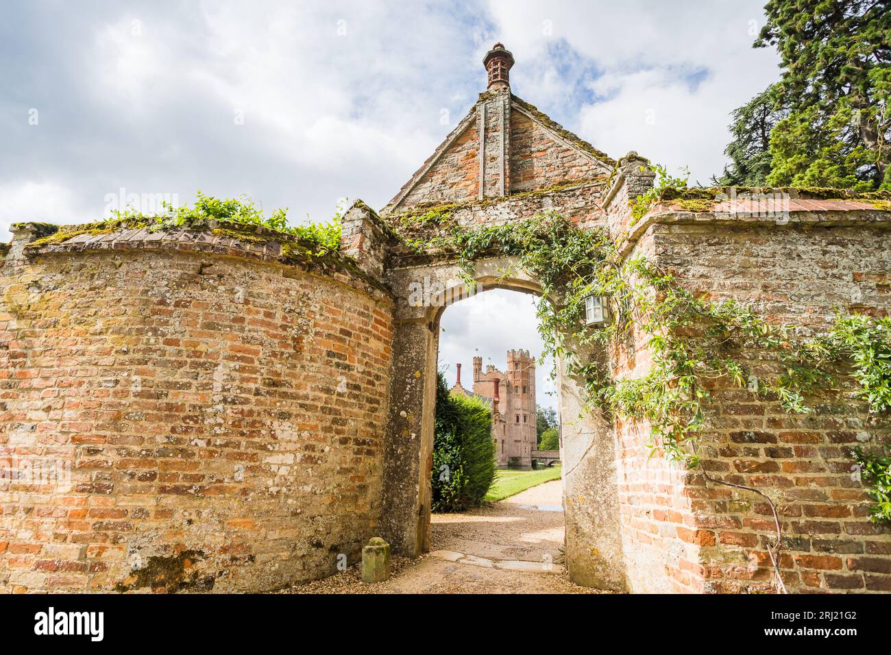 Oxburgh Hall pictured through an old brick arch in Norfolk seen in ...