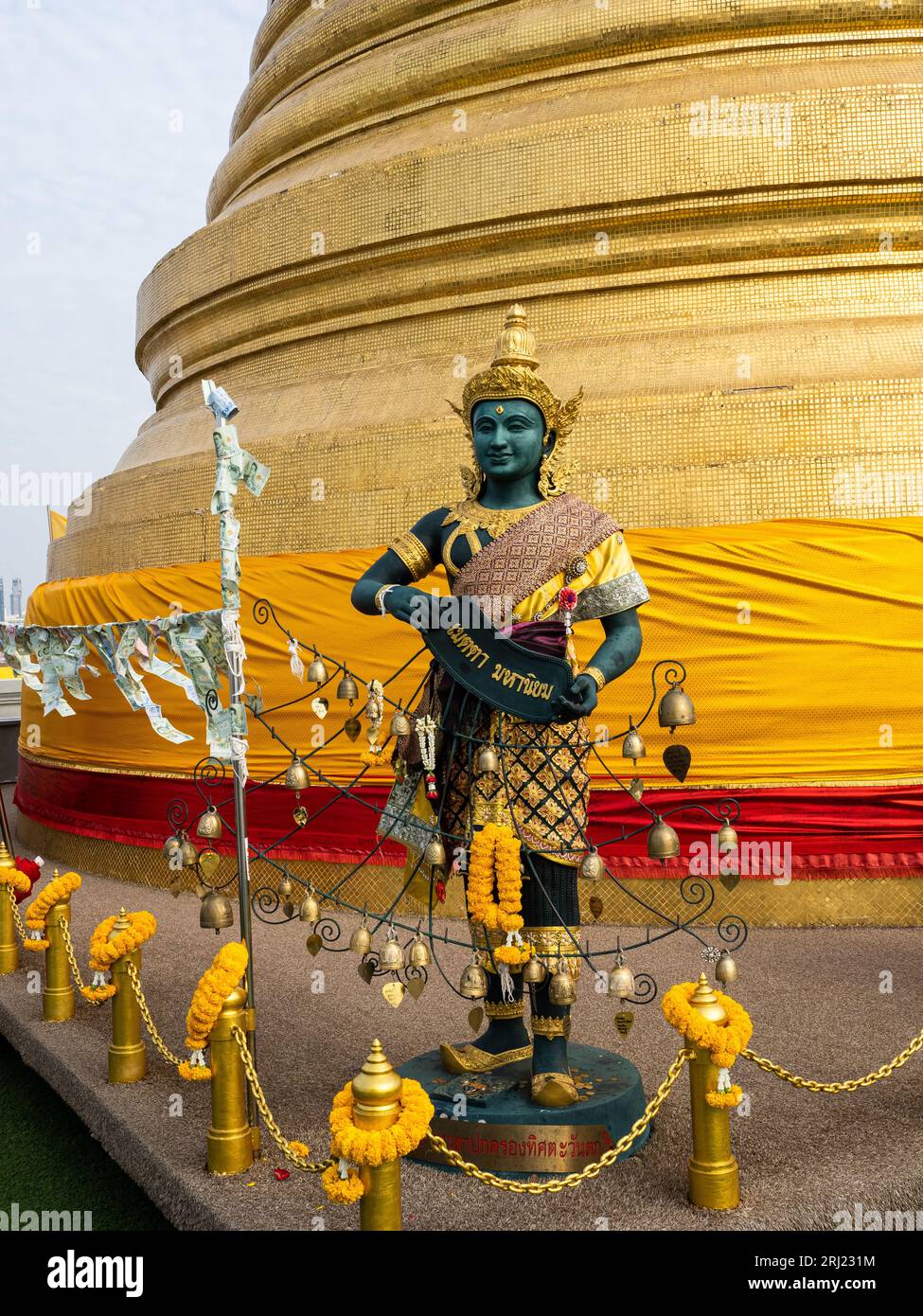 Captured up close, a statue rests beneath the temple's gilded spire ...