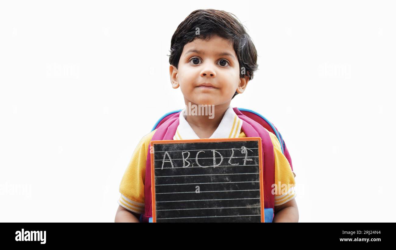 Portrait of happy cute little indian boy in school uniform holding ...