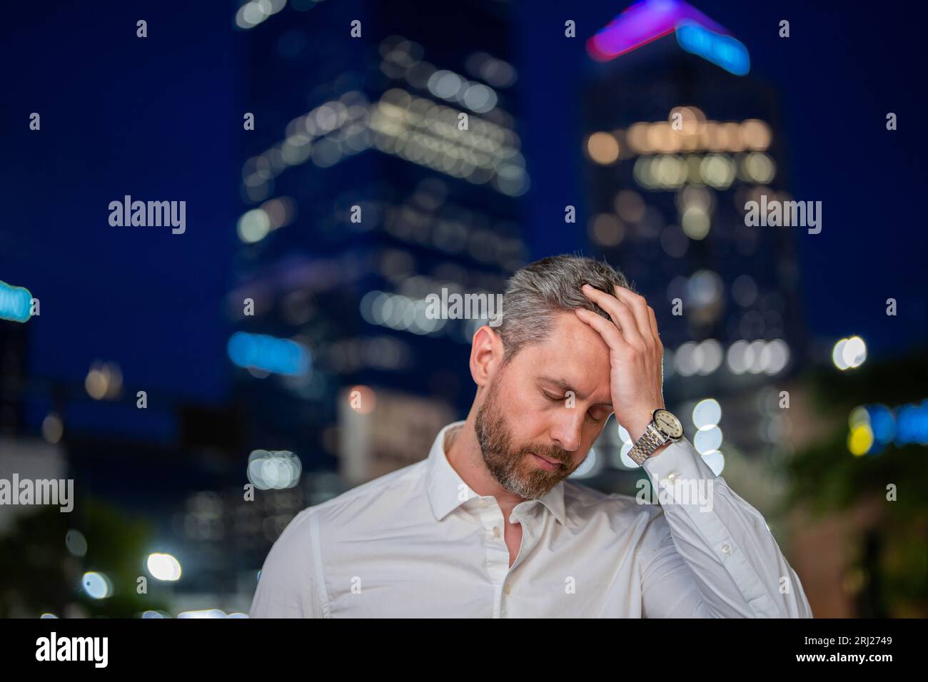 Close up portrait of stressed business man on night city background. Stressed ceo manager have ...