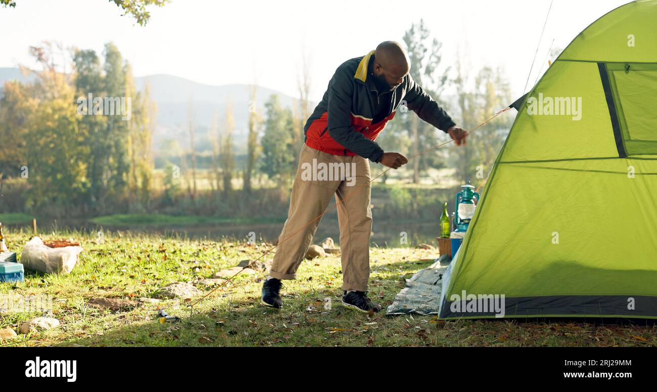Camping, tent and black man setup in nature for shelter on outdoor ...