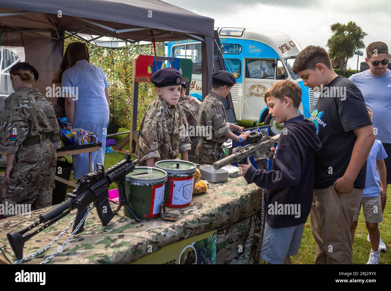 Young Army Cadets in military uniform show other children weapons at a ...