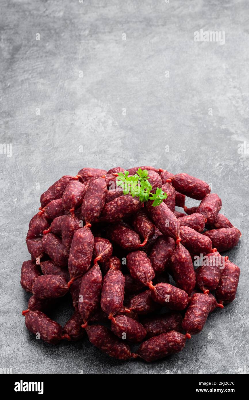 Mini salami sausages in wooden bowl on gray background Stock Photo - Alamy
