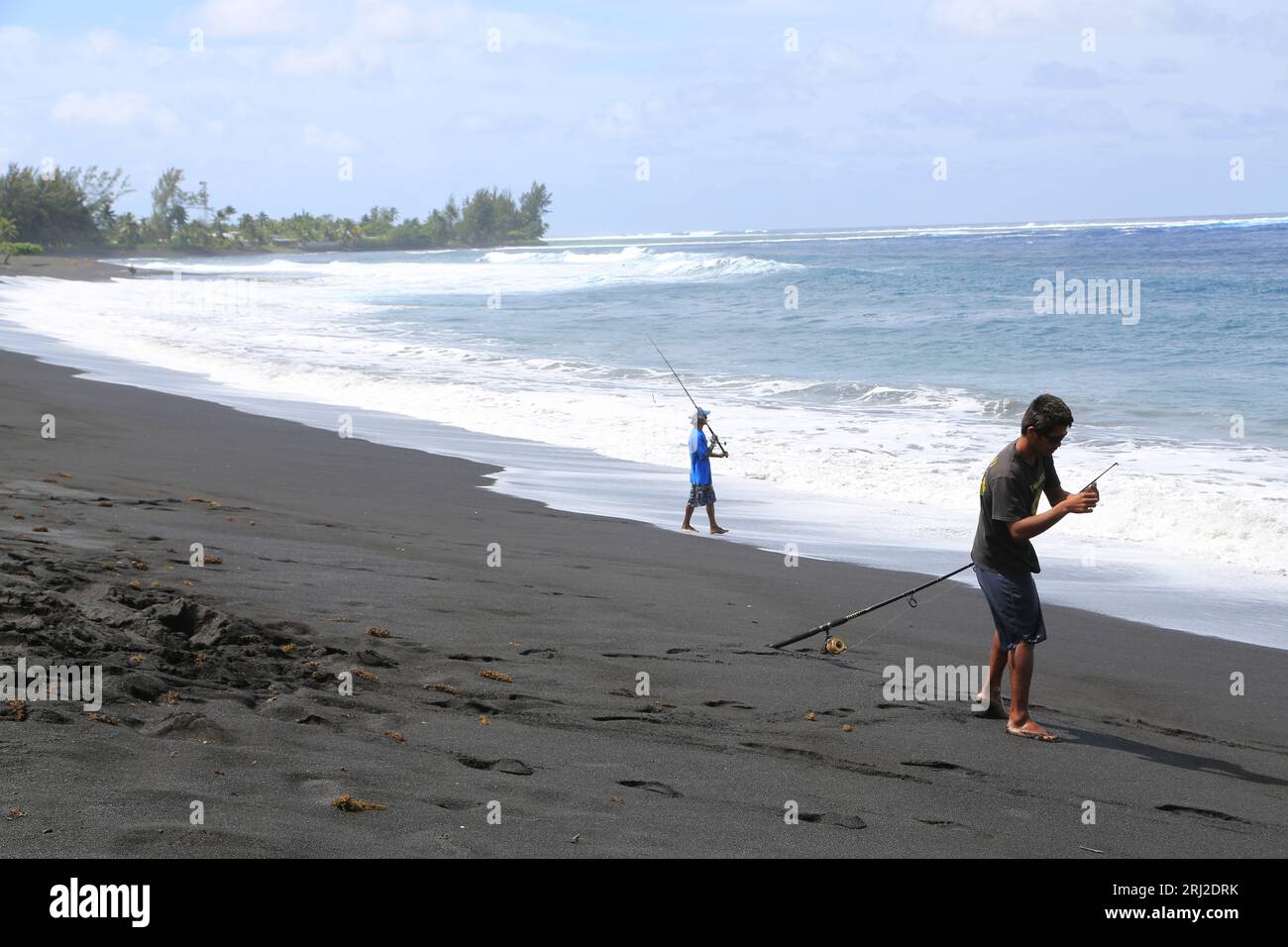 Pêche à la ligne sur la plage de sable noir volcanique de Papara à ...