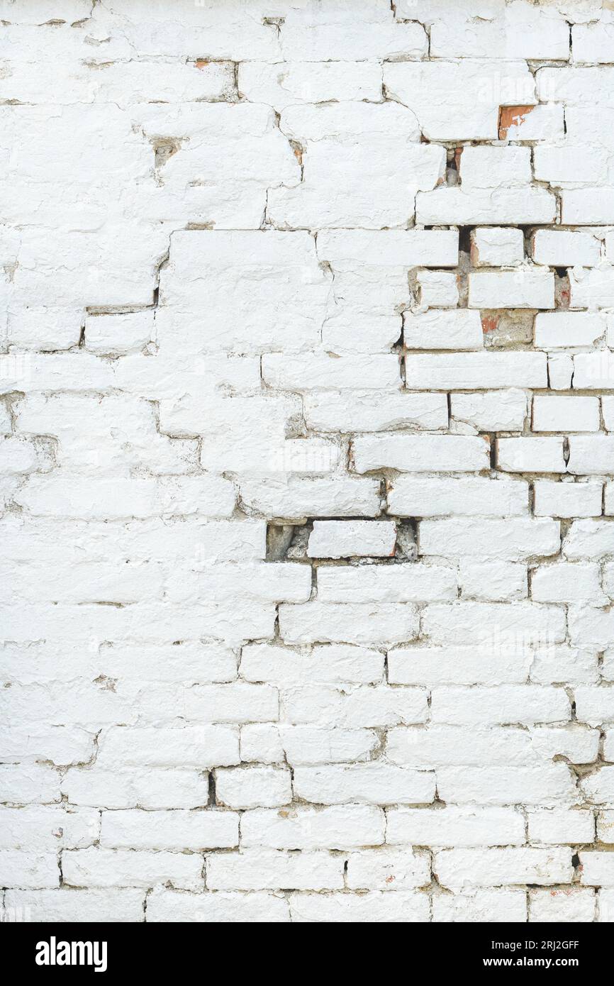 Old damaged brick wall painted in white color, vertical image Stock ...