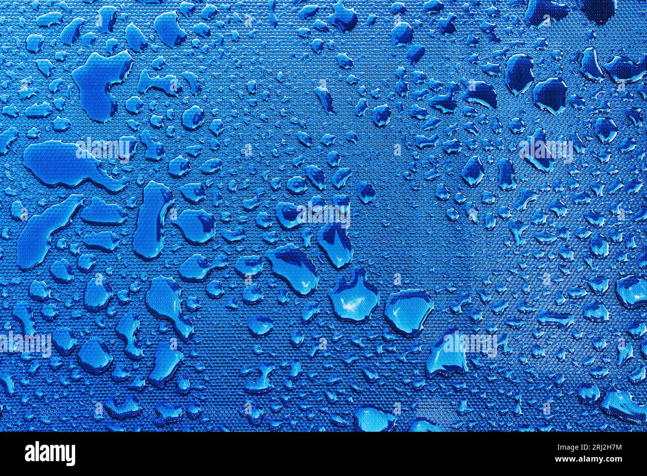 Water drops with light reflection on blue plastic surface as background ...