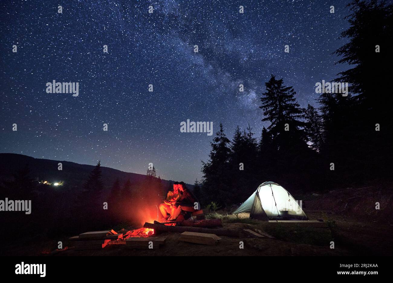 Overnight camping sojourn in mountains. Man and woman, ardent explorers ...