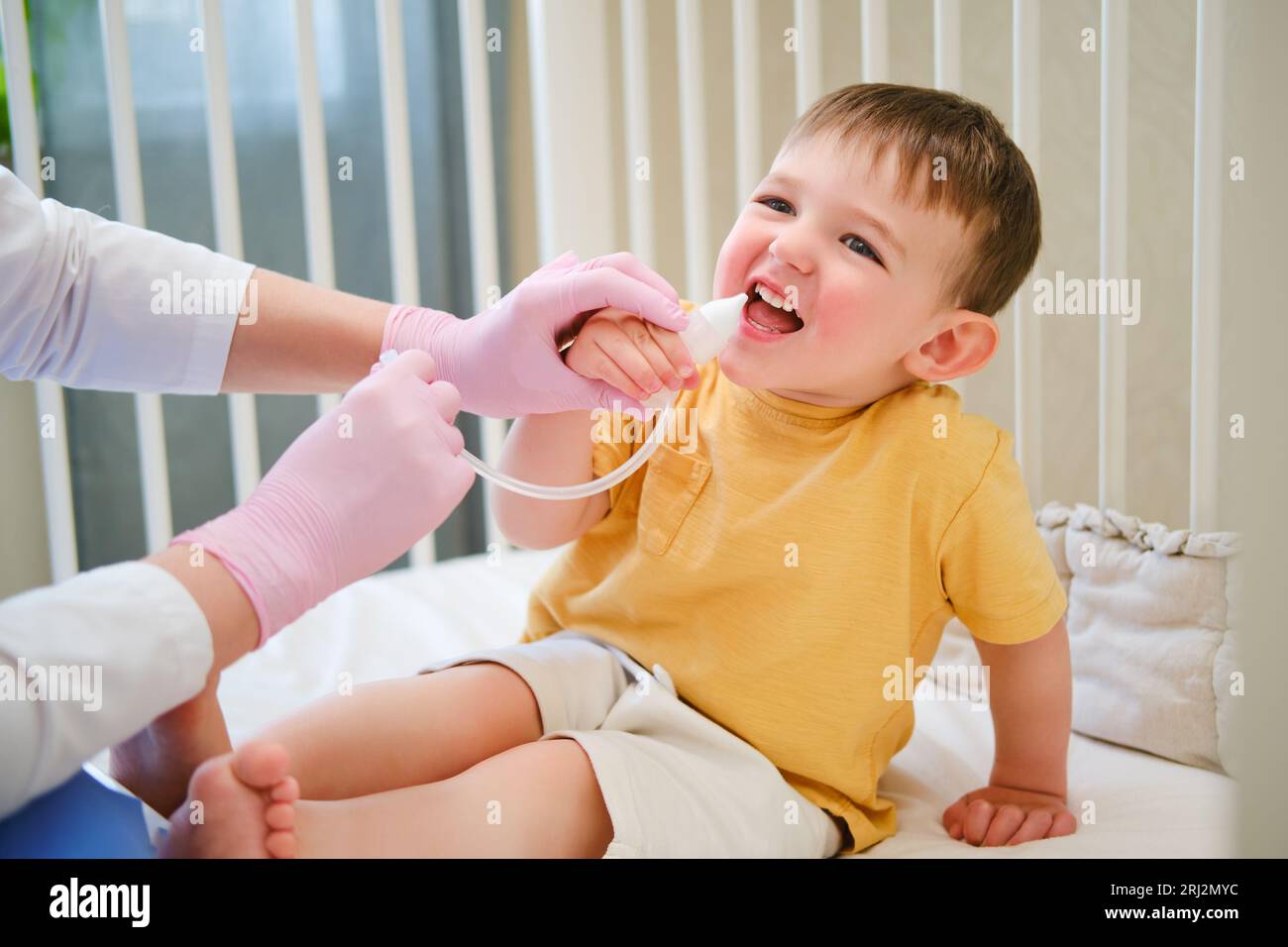 The otolaryngologist using a pediatric aspirator with a vacuum pump to ...