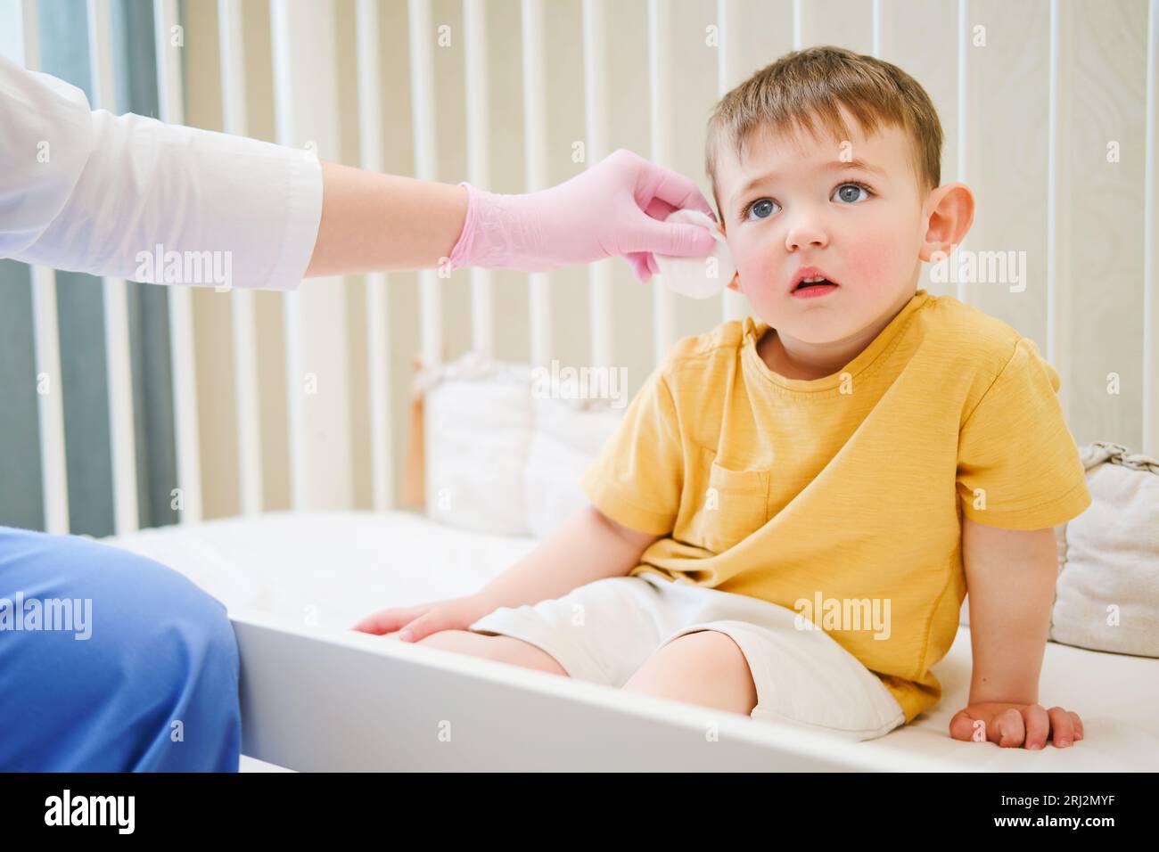 The pediatrician regular cleaning of the baby's face with a cotton pad ...