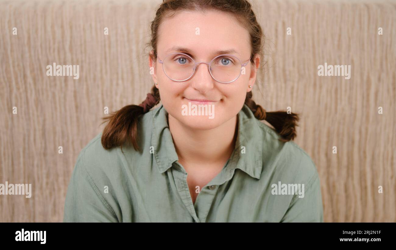 Portrait of a happy smiling adult woman sitting on a sofa, female age ...