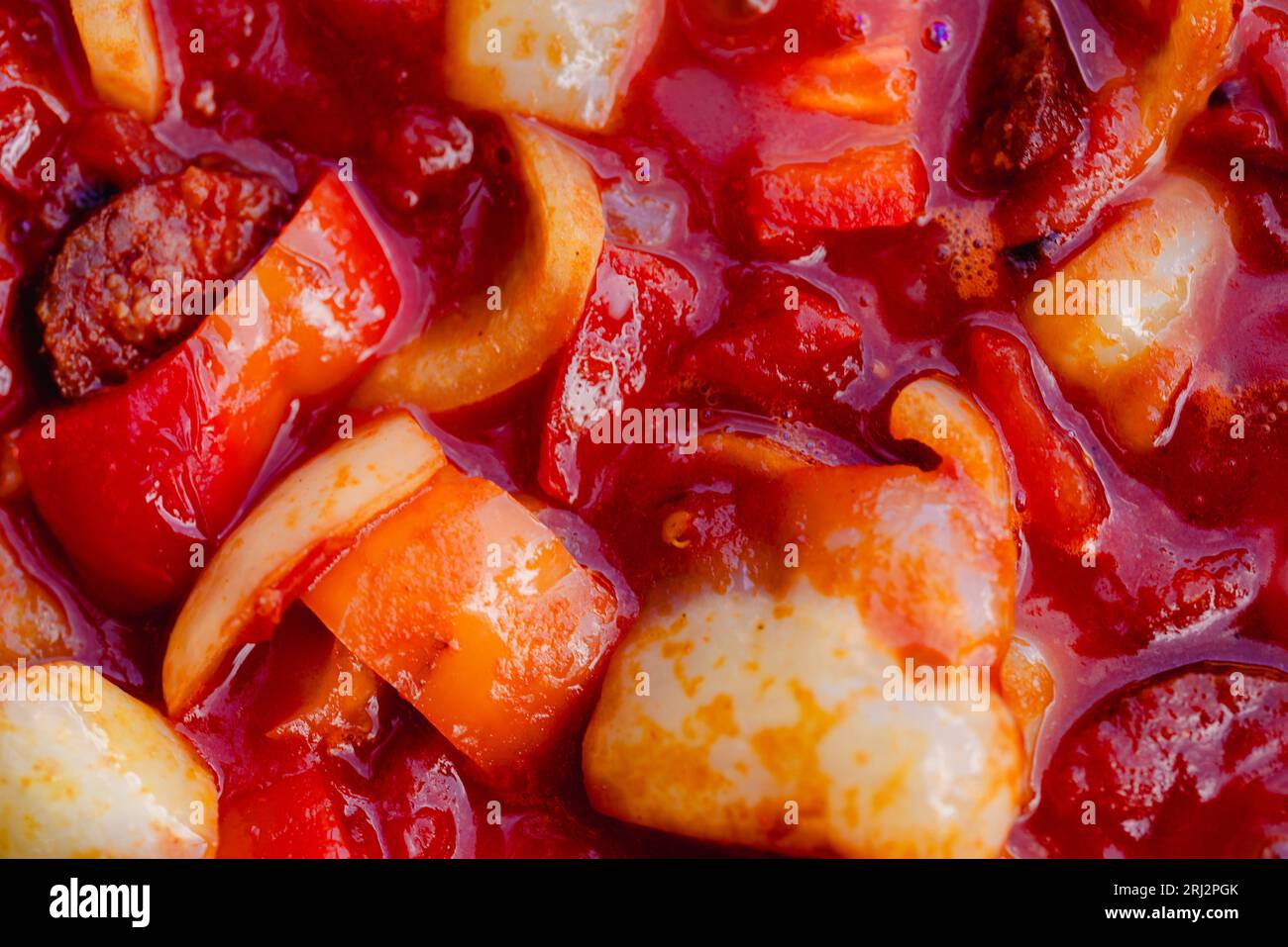 Letcho, stew with courgette and sausages. The food being cooked is ...