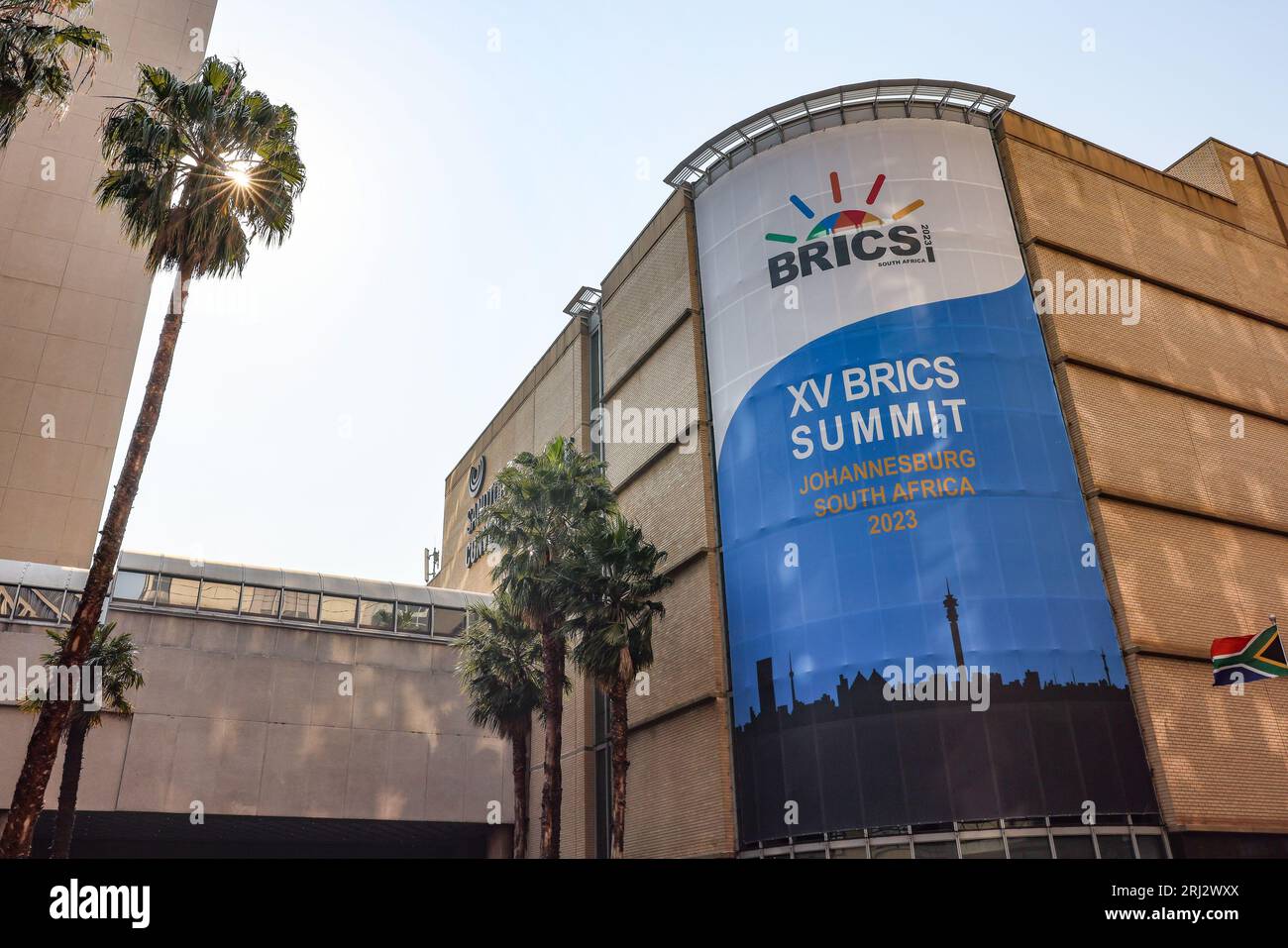 A large banner advertising the 2023 BRIC's summit hangs on the side of ...
