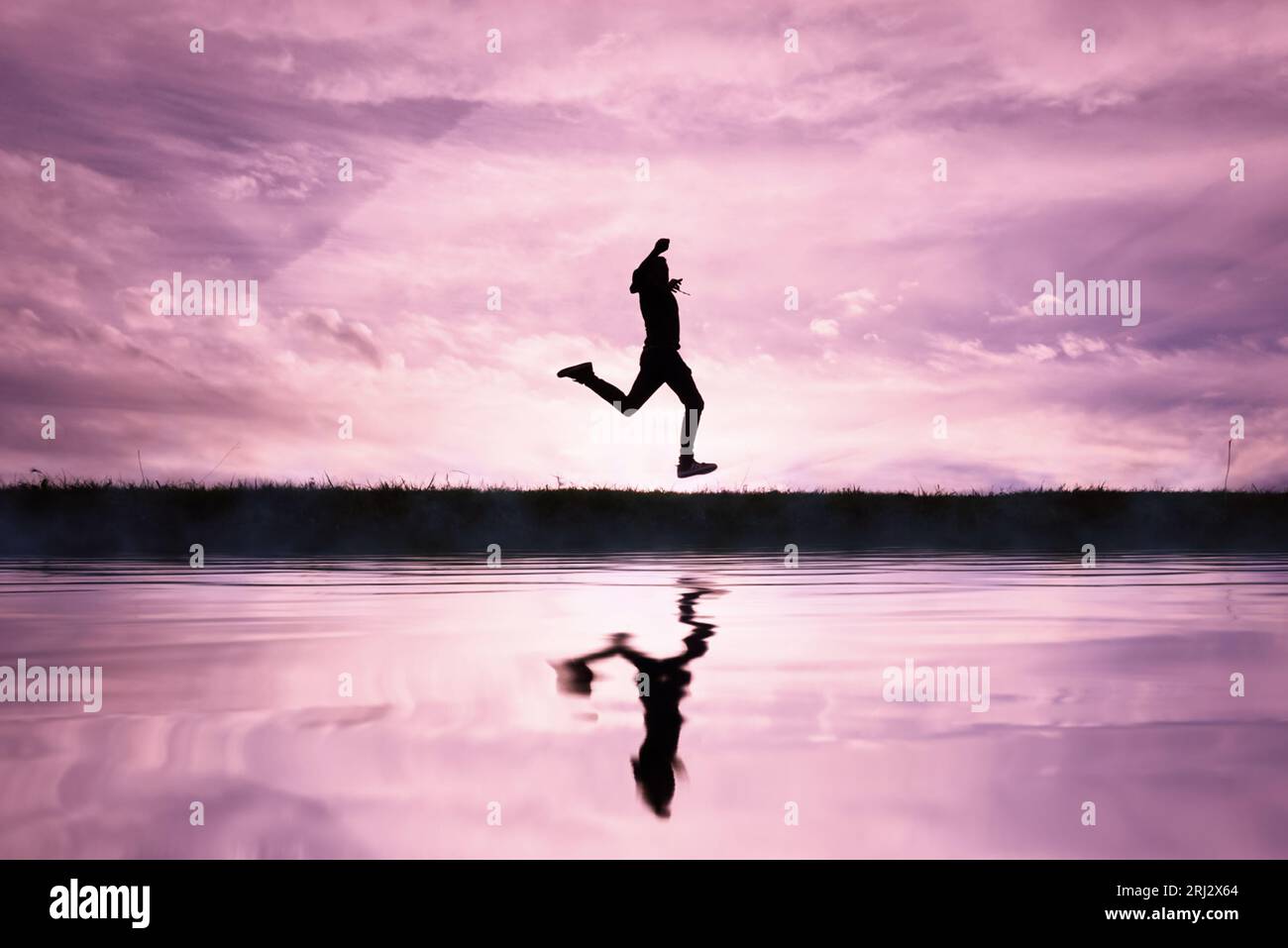 man jumping over a pond with a sunset background Stock Photo - Alamy