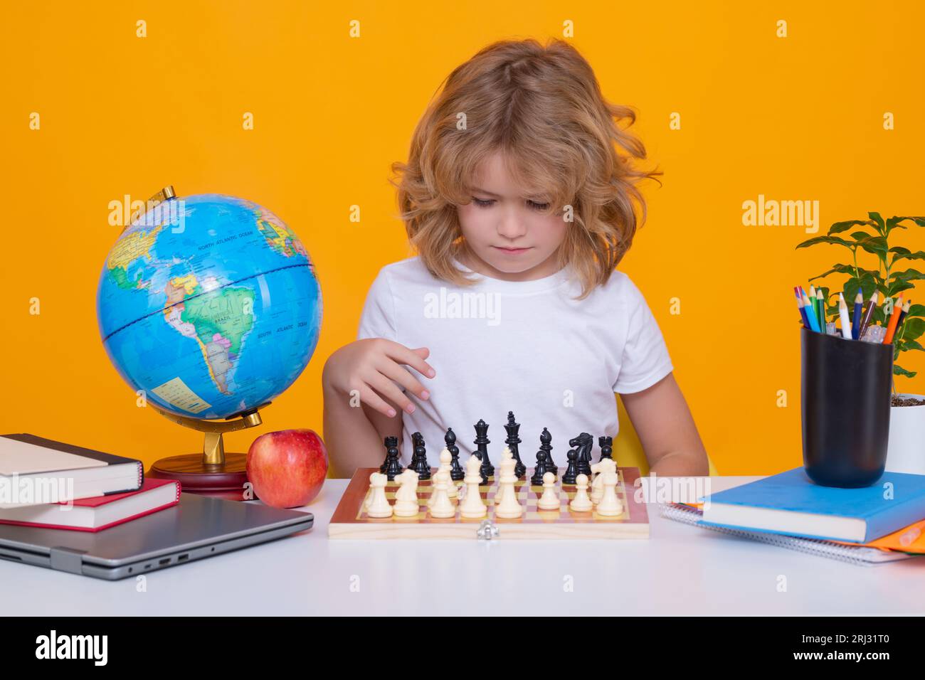 Clever concentrated and thinking child playing chess. Child boy ...