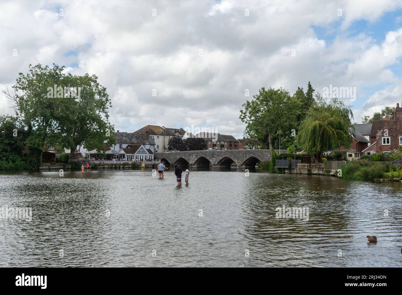 Fordingbridge, UK - August 19th 2023: People wading in the River Avon ...