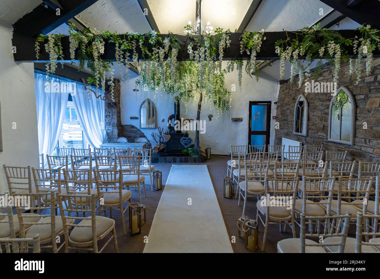 An empty wedding ceremony room featuring a large number of tables and ...