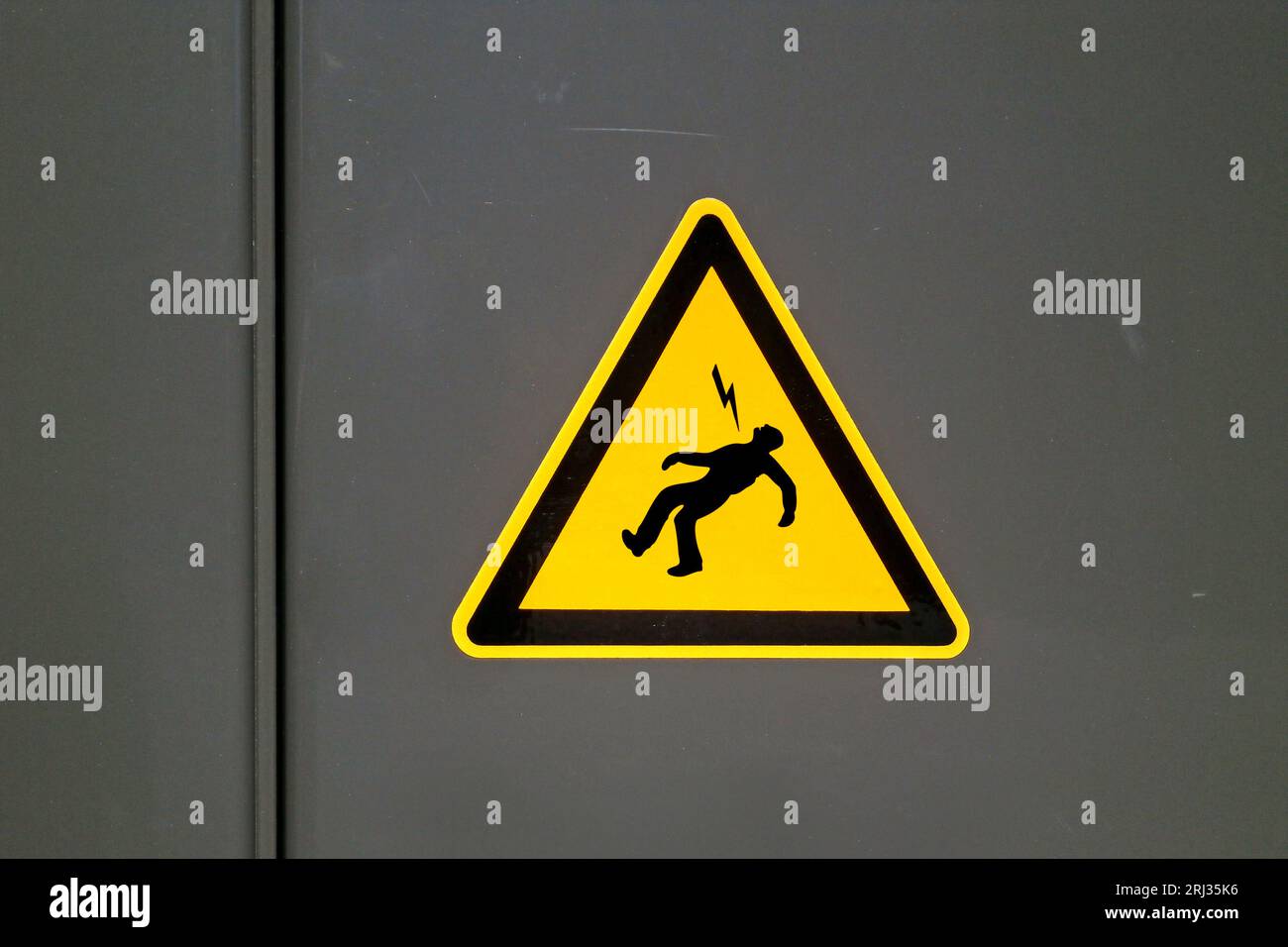 Yellow caution sign on a metal door warning about "Danger of death ...