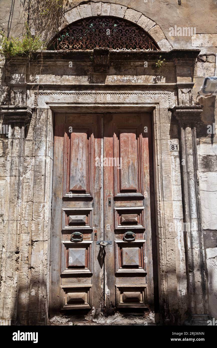 Old weather wooden door with stone arched lintel at an abandoned old ...