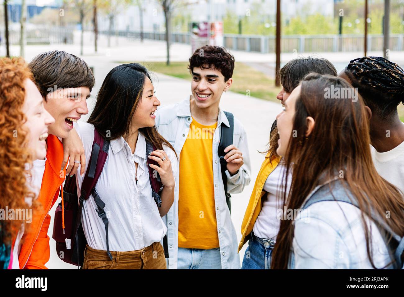 Diverse teenage student group having fun together talking at college ...