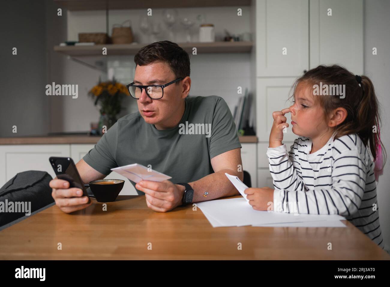 Father and child girl doing origami crafts together. Modern parenthood ...