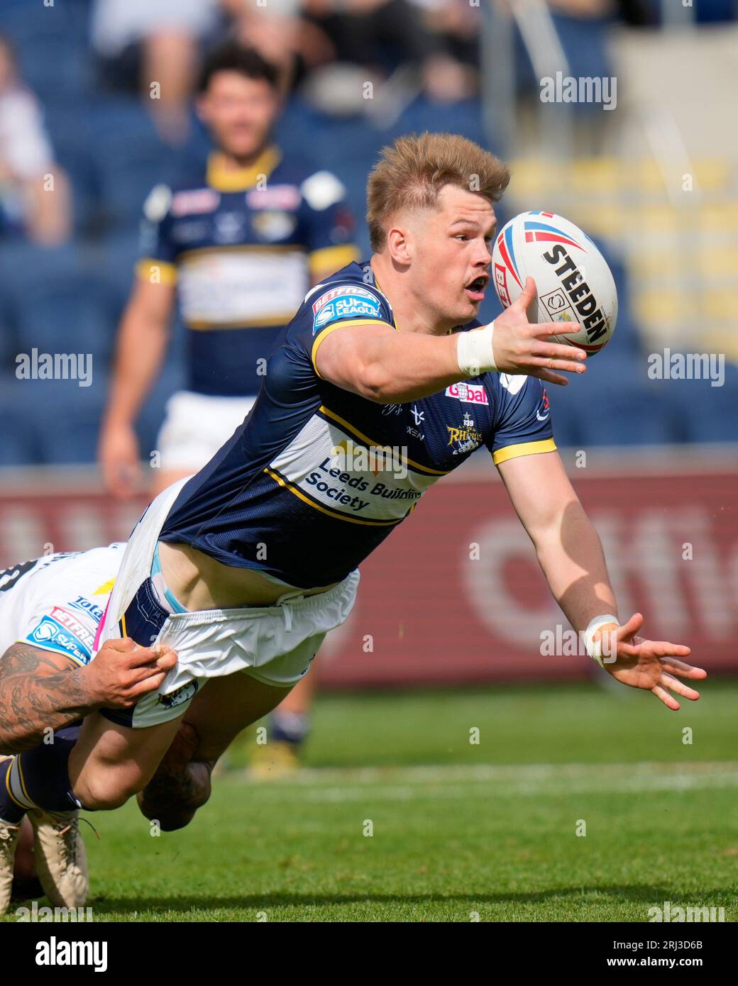 Tom Holroyd #18 of Leeds Rhinos offloads the ball during the Betfred ...