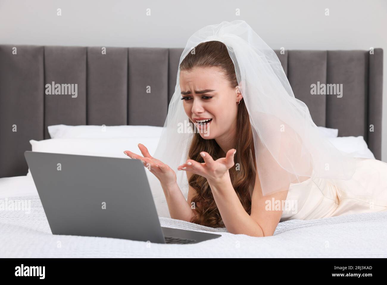 Emotional bride with laptop on bed in bedroom Stock Photo - Alamy