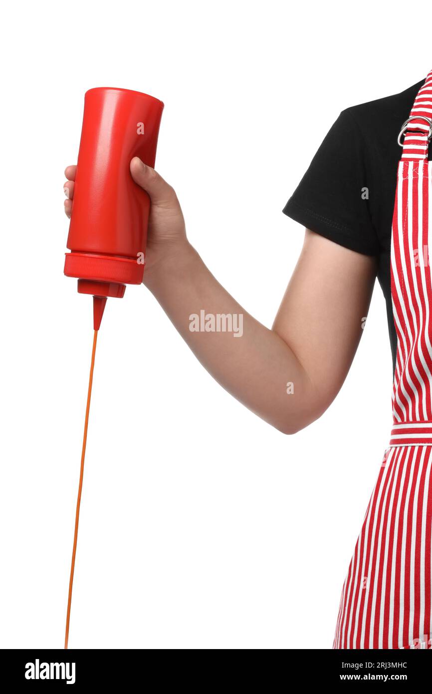 Woman pouring tasty ketchup from bottle on white background, closeup ...
