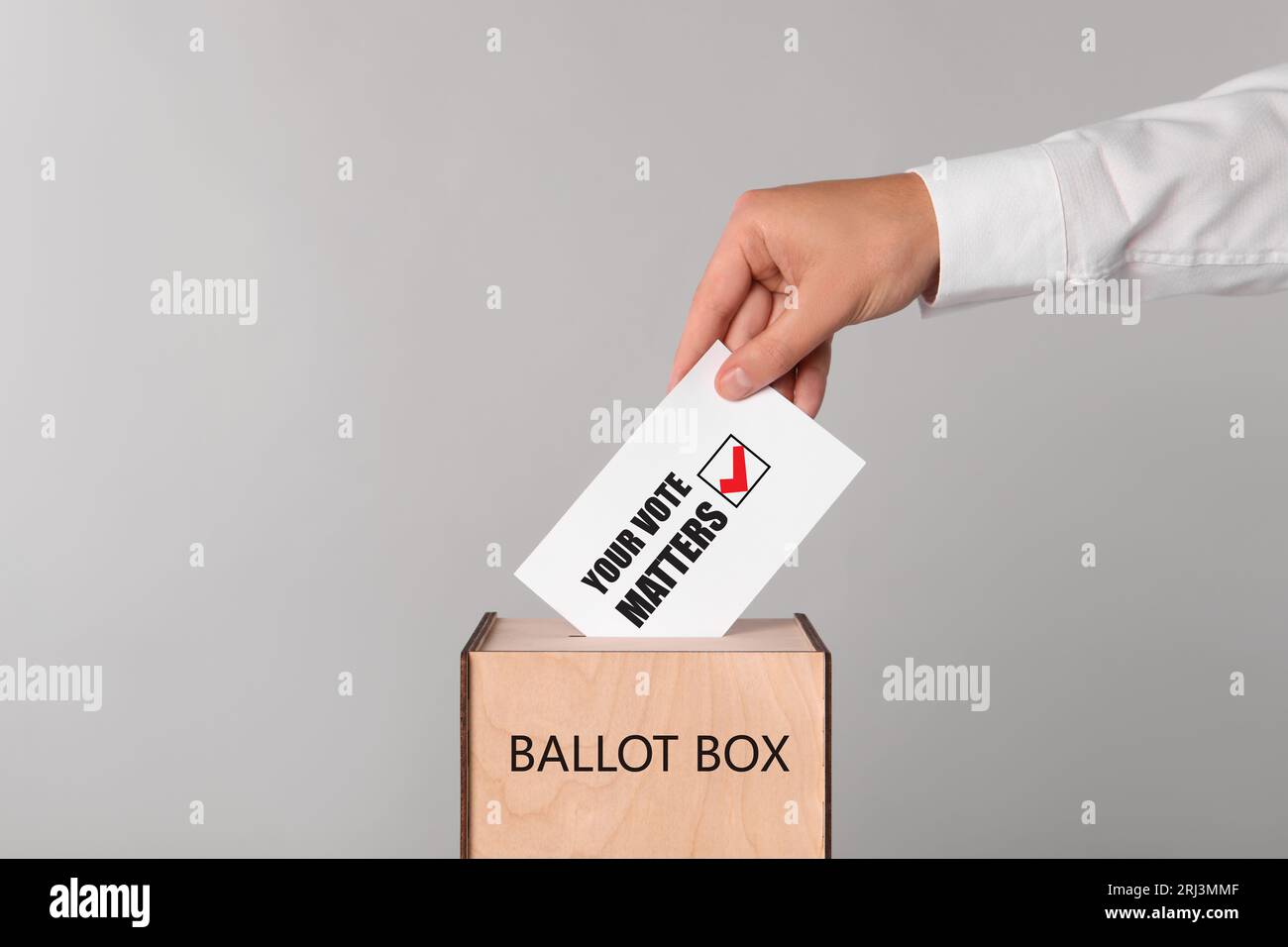 Man putting paper with text Your Vote Matters and tick into ballot box ...