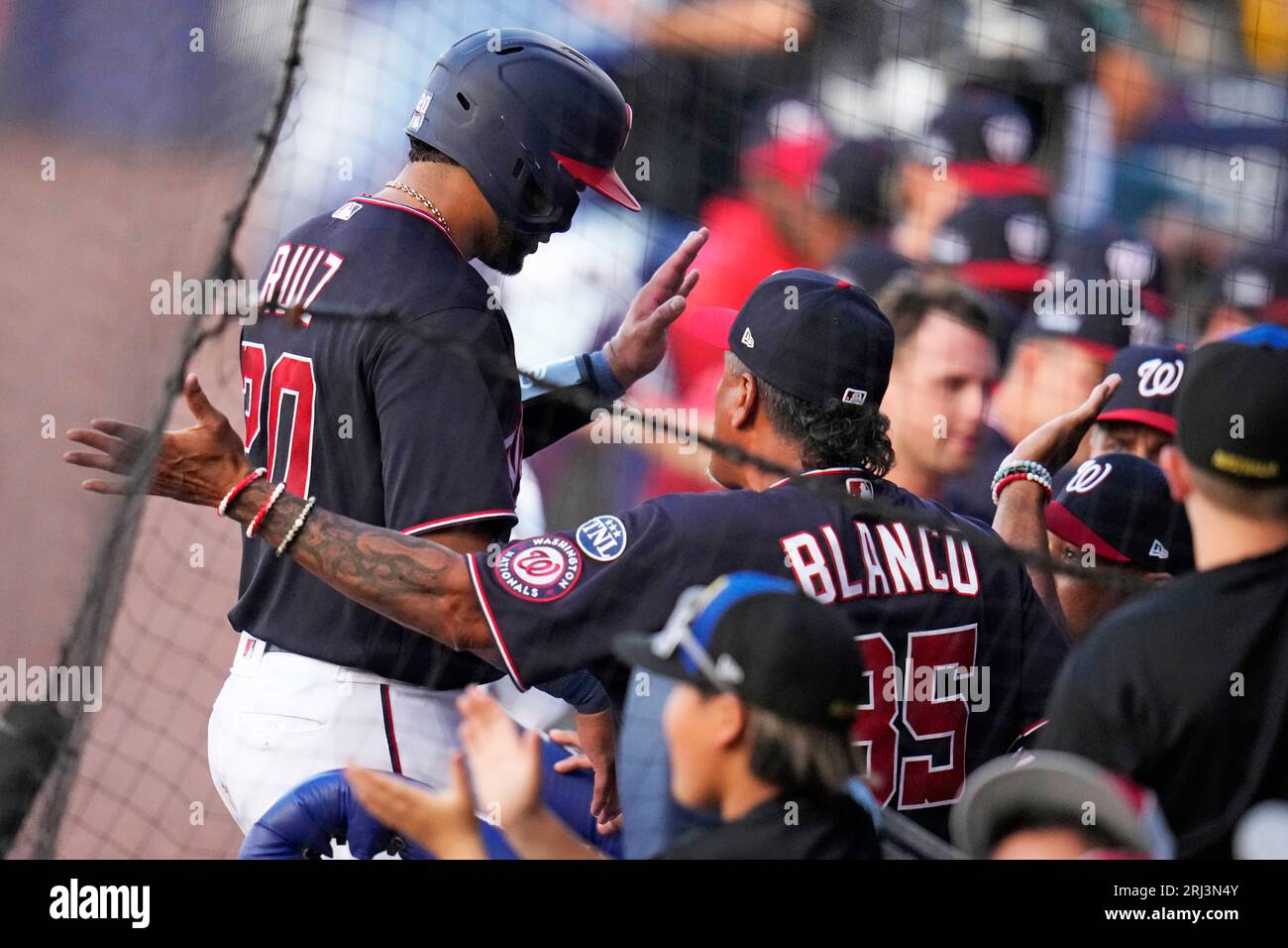 Washington Nationals' Keibert Ruiz (20) is greeted at the dugout steps by Henry Blanco (35 ...