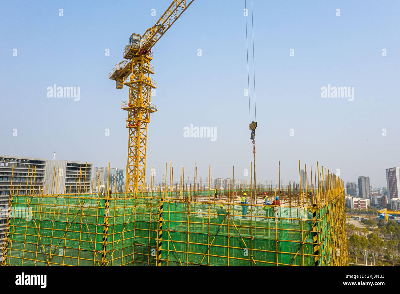 A large crane is attached to a tower in the middle of a bustling ...