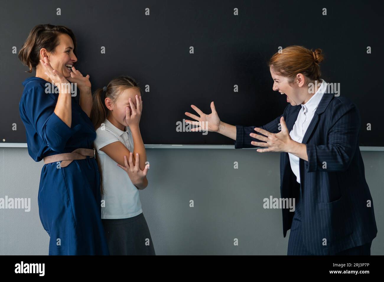 The teacher screams at the schoolgirl and her mother standing at the ...