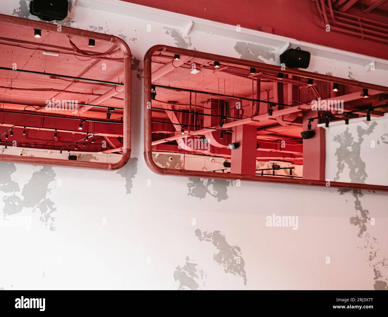 A row of mirrors are affixed to the wall above a bright red fire ... A row of mirrors are affixed to the wall above a bright red fire ...