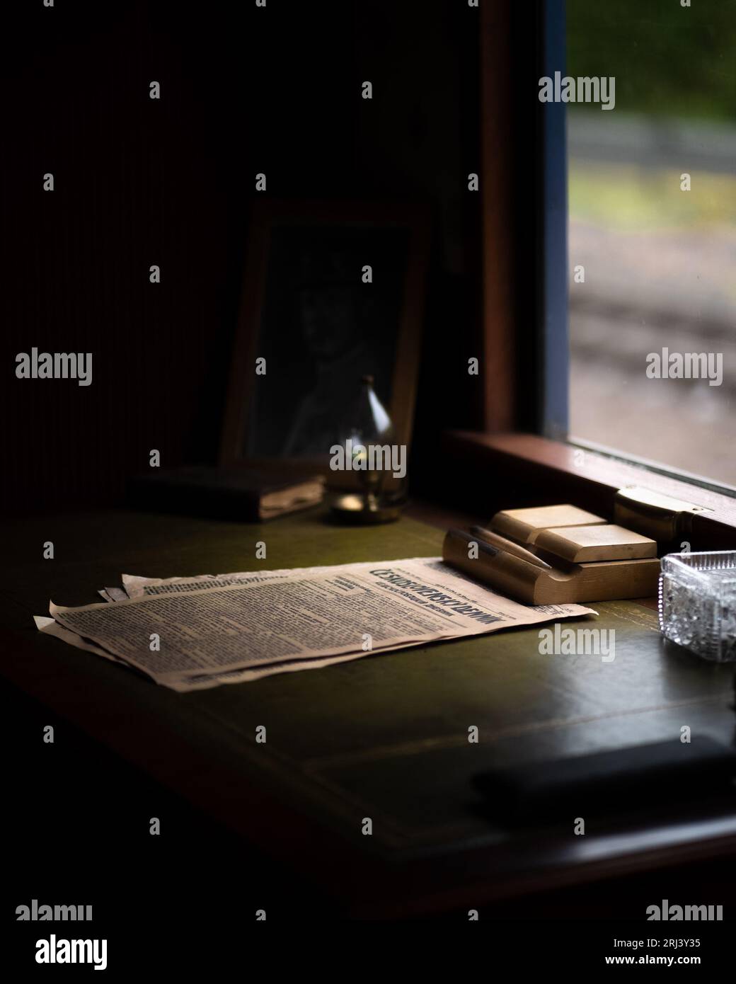 A wooden desk with newspapers scattered on top of it in a tidy and ...