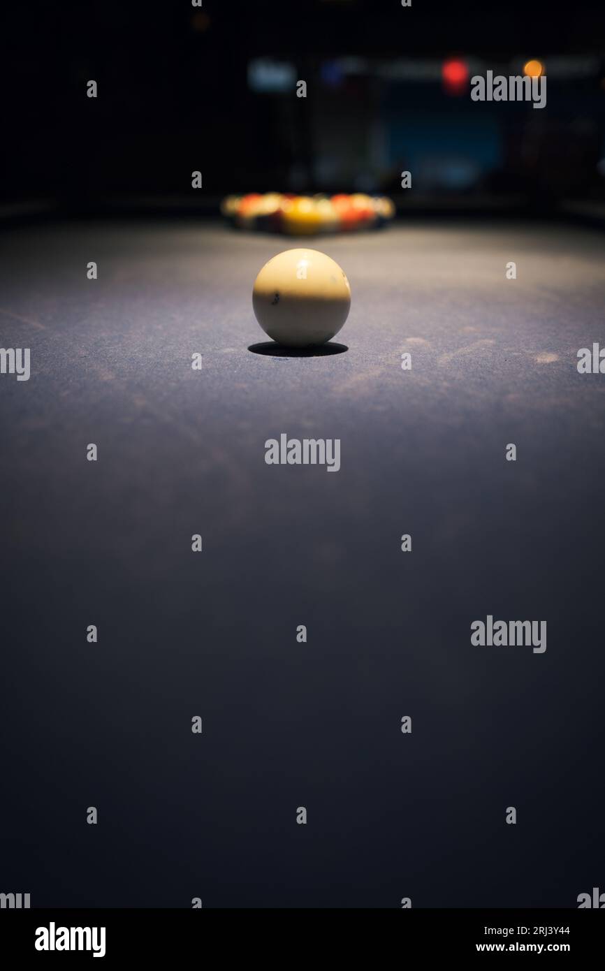 A vibrant and pristine pool ball sits atop a billiards table, ready to ...