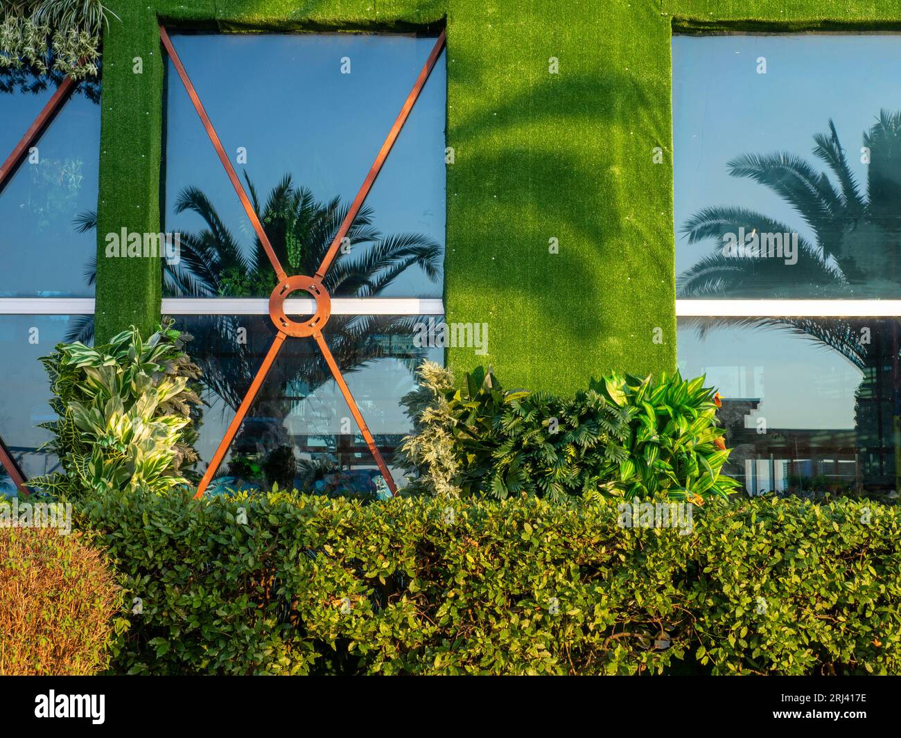 Facade of the building in greenery. Decorating works. The wall of the ...