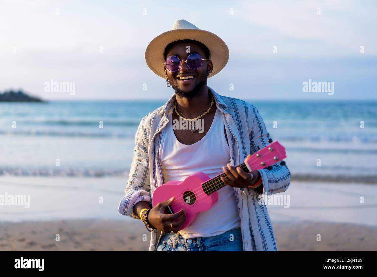 A shallow focus of a handsome cheerful black man with a fedora hat ...