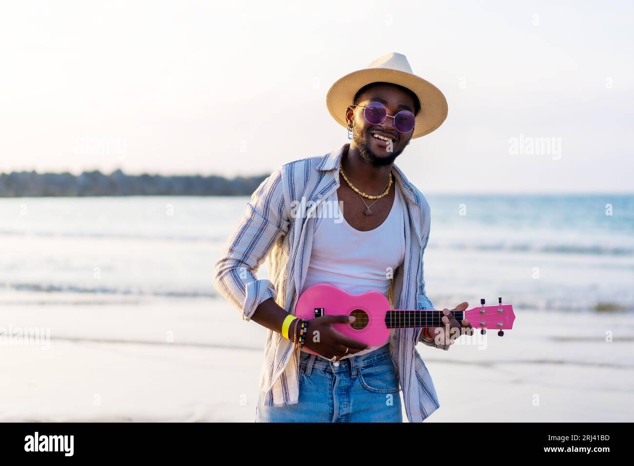 A shallow focus of a handsome cheerful black man with a fedora hat ...