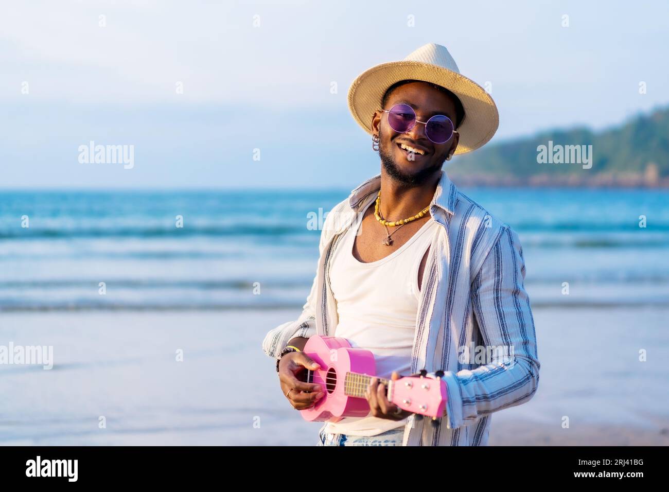 A shallow focus of a handsome cheerful black man with a fedora hat ...
