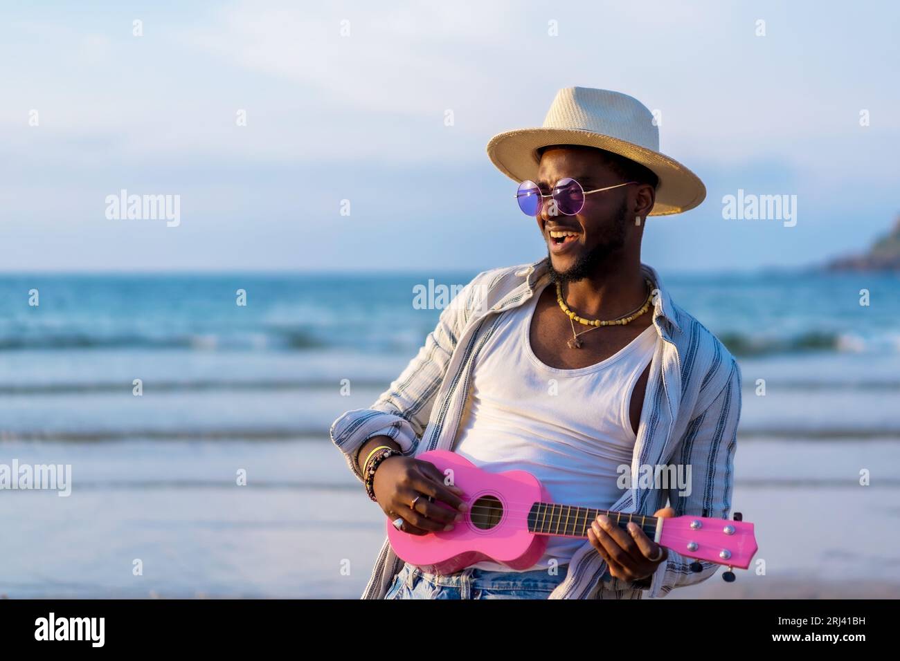 A shallow focus of a handsome cheerful black man with a fedora hat ...