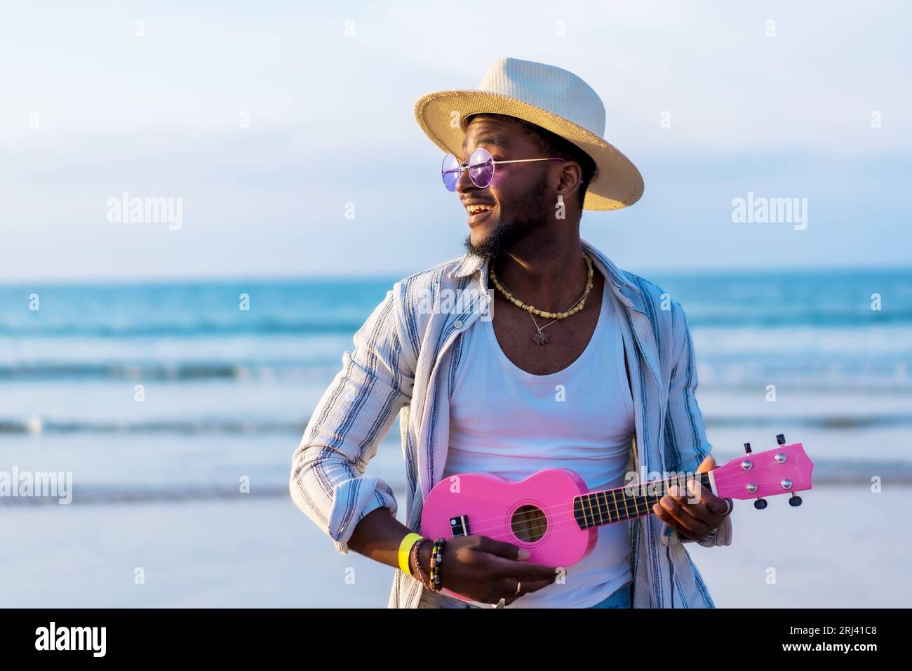 A shallow focus of a handsome cheerful black man with a fedora hat ...