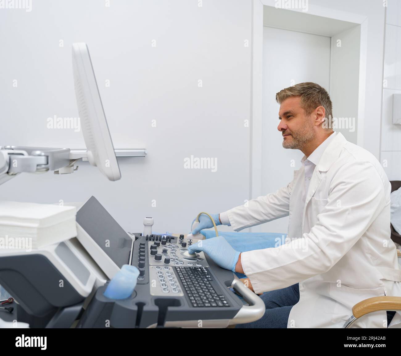 Male sonographer doing abdominal ultrasound scanning for woman patient ...