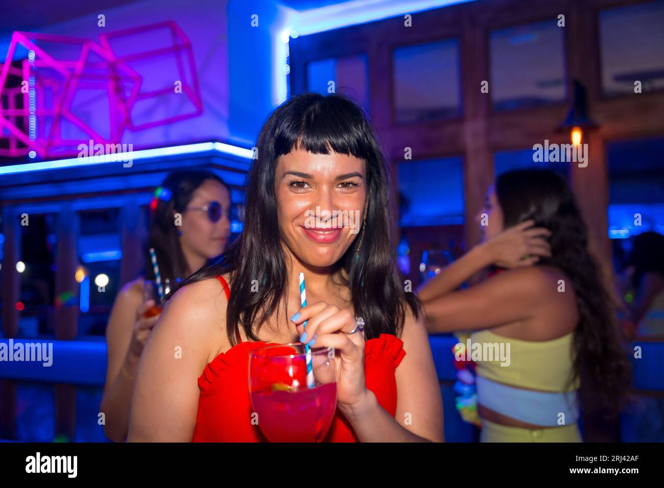 A shallow focus of three cheerful women drinking cocktails and ...