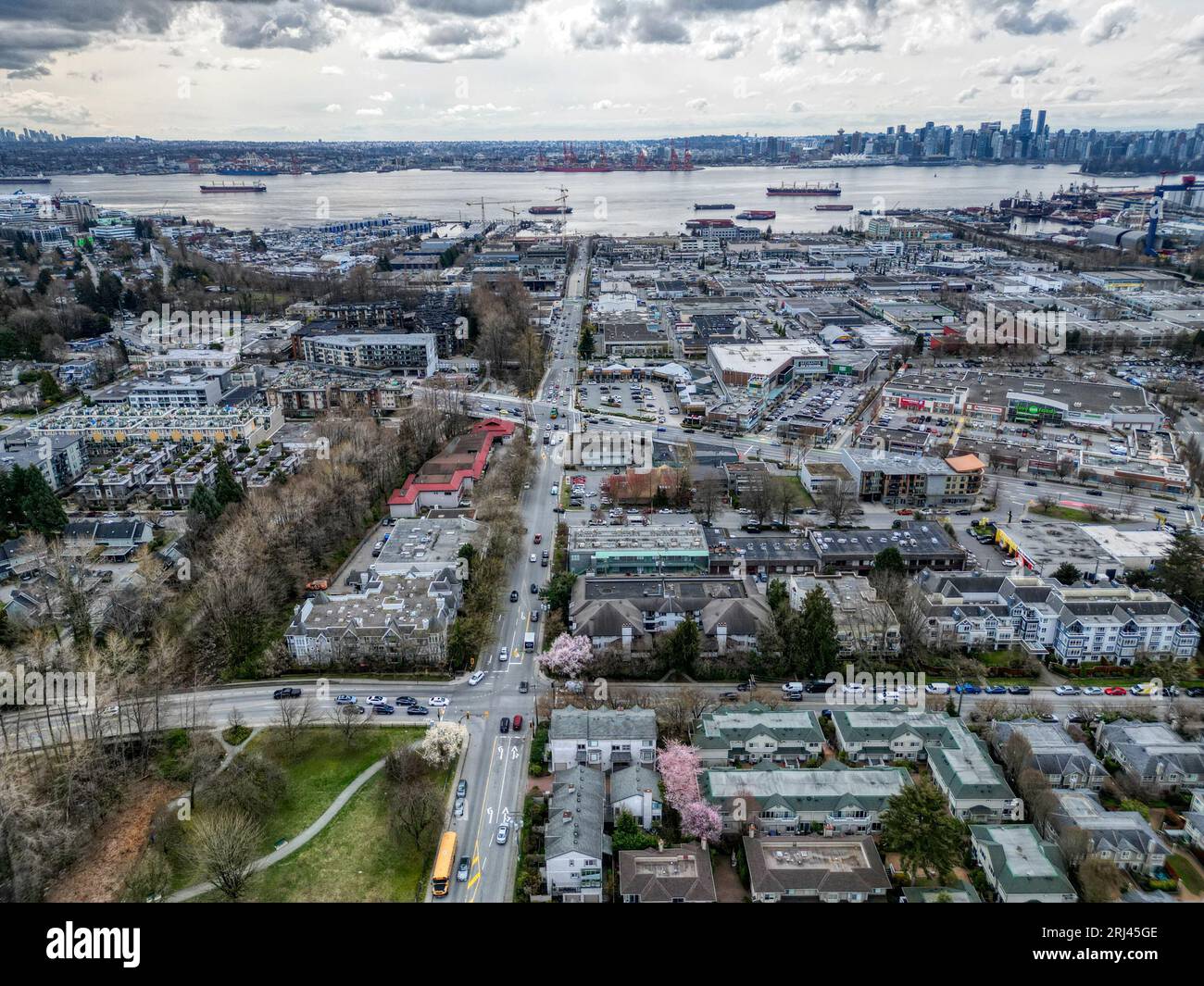 An aerial view of a cityscape featuring many cars parked on a street in ...