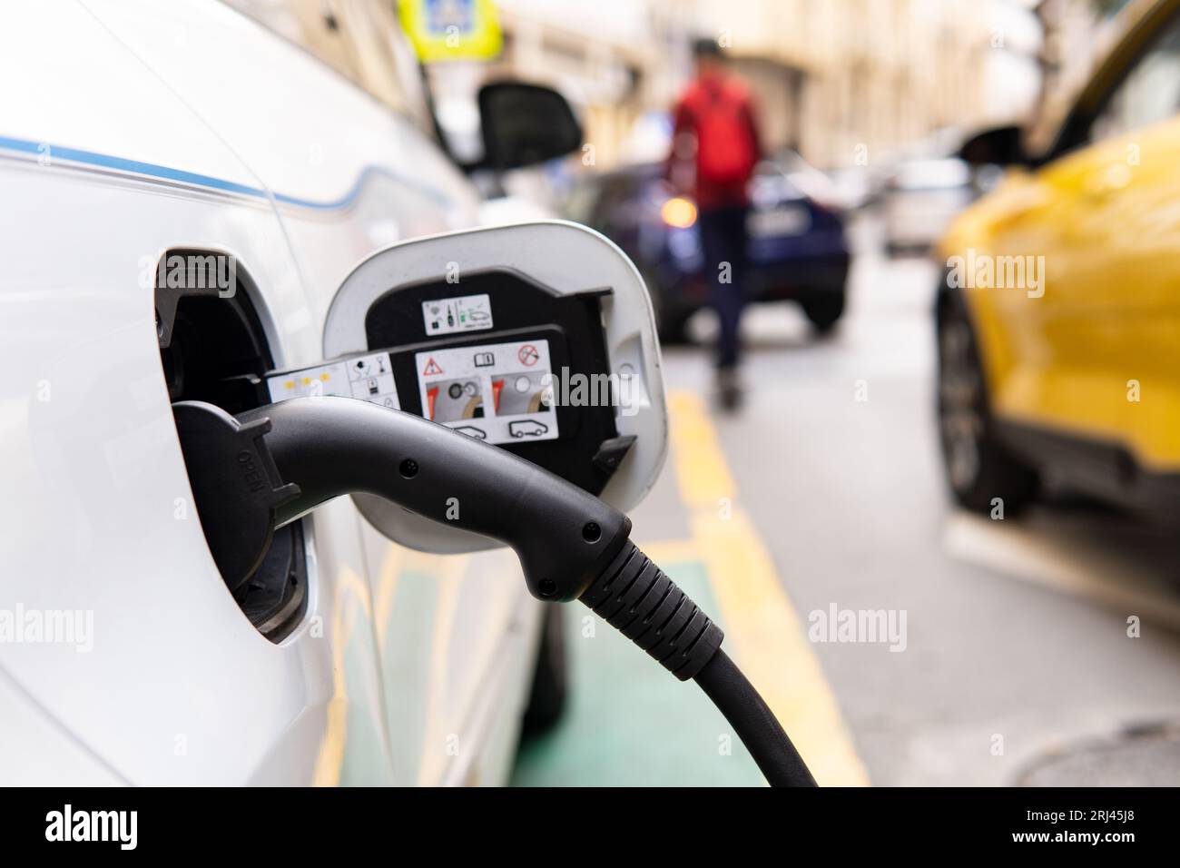 Photo of a car recharging its battery at an electric vehicle charging ...