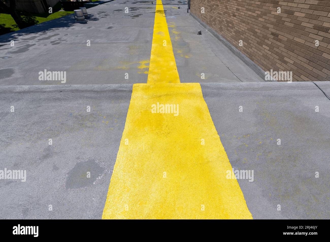 Painted safety yellow walkway on new spray foam roof for foot traffic ...