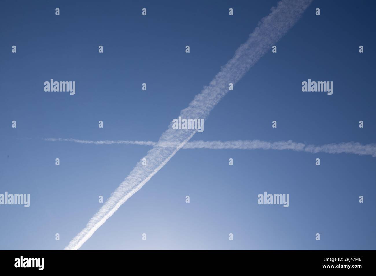 Chemical trails in the sky making an X Stock Photo - Alamy