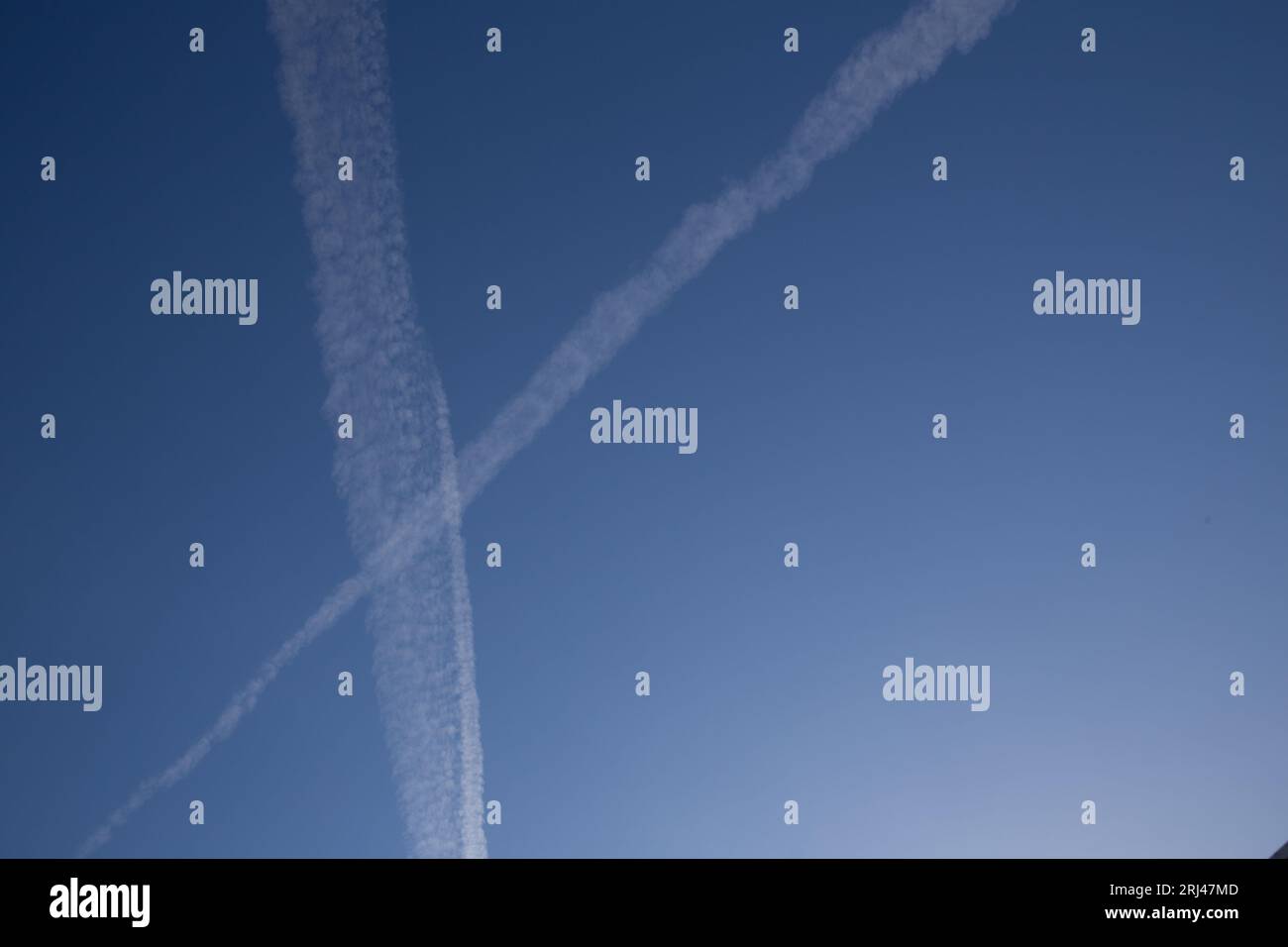 Chemical trails in the sky making an X Stock Photo - Alamy