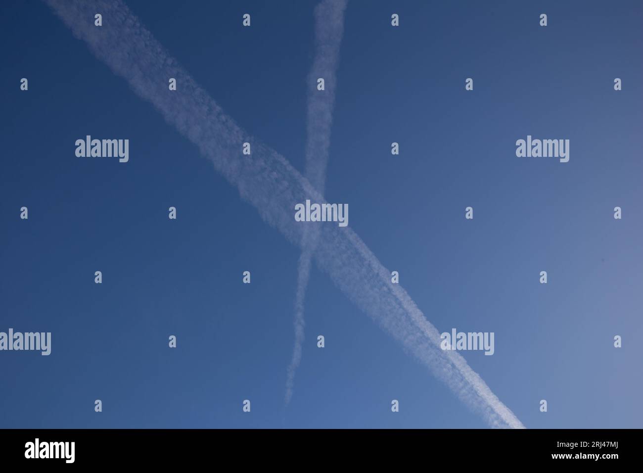 Chemical trails in the sky making an X Stock Photo - Alamy